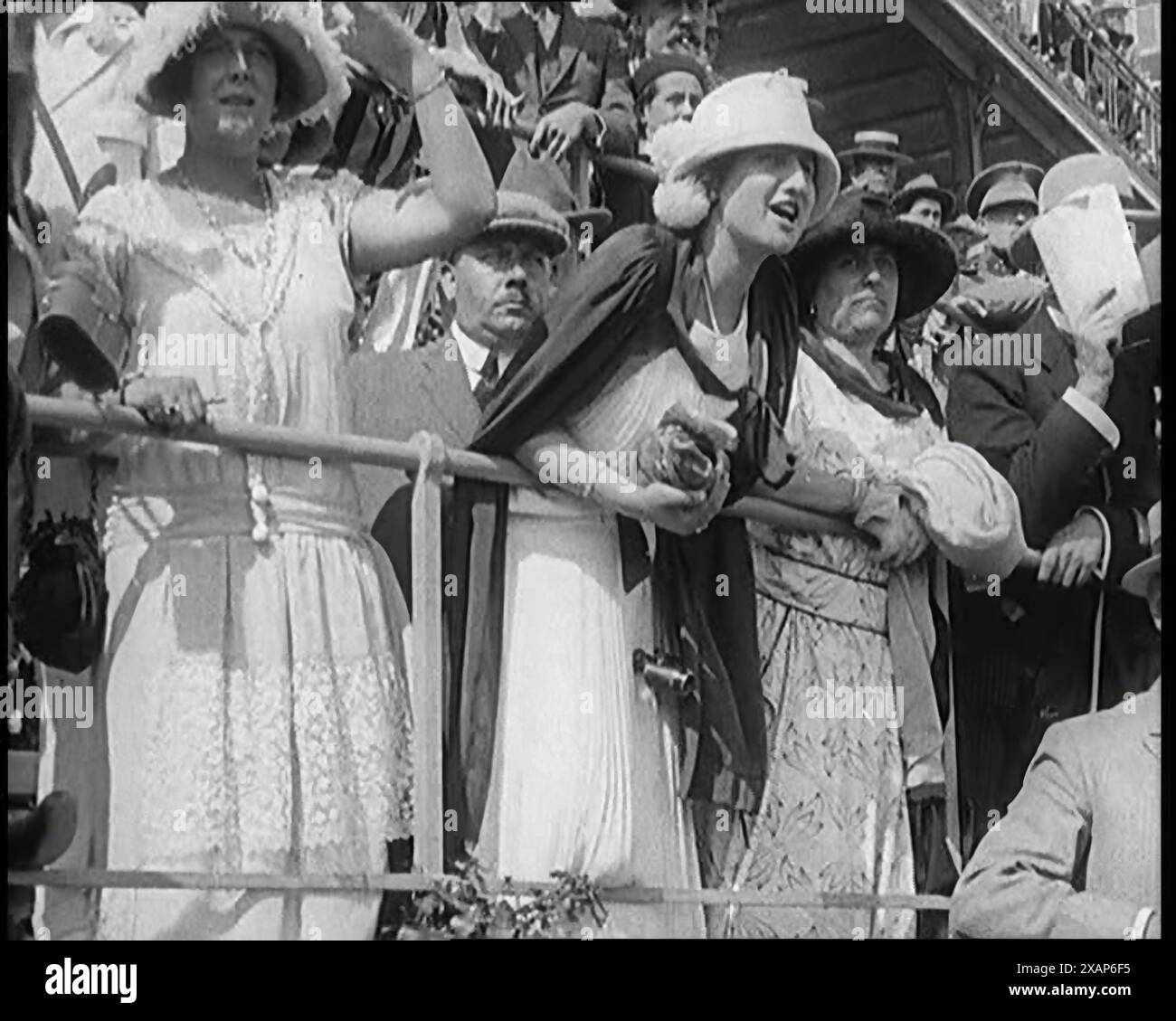 A Large Crowd of Civilians Wearing Smart Outfits and Hats Watching a ...