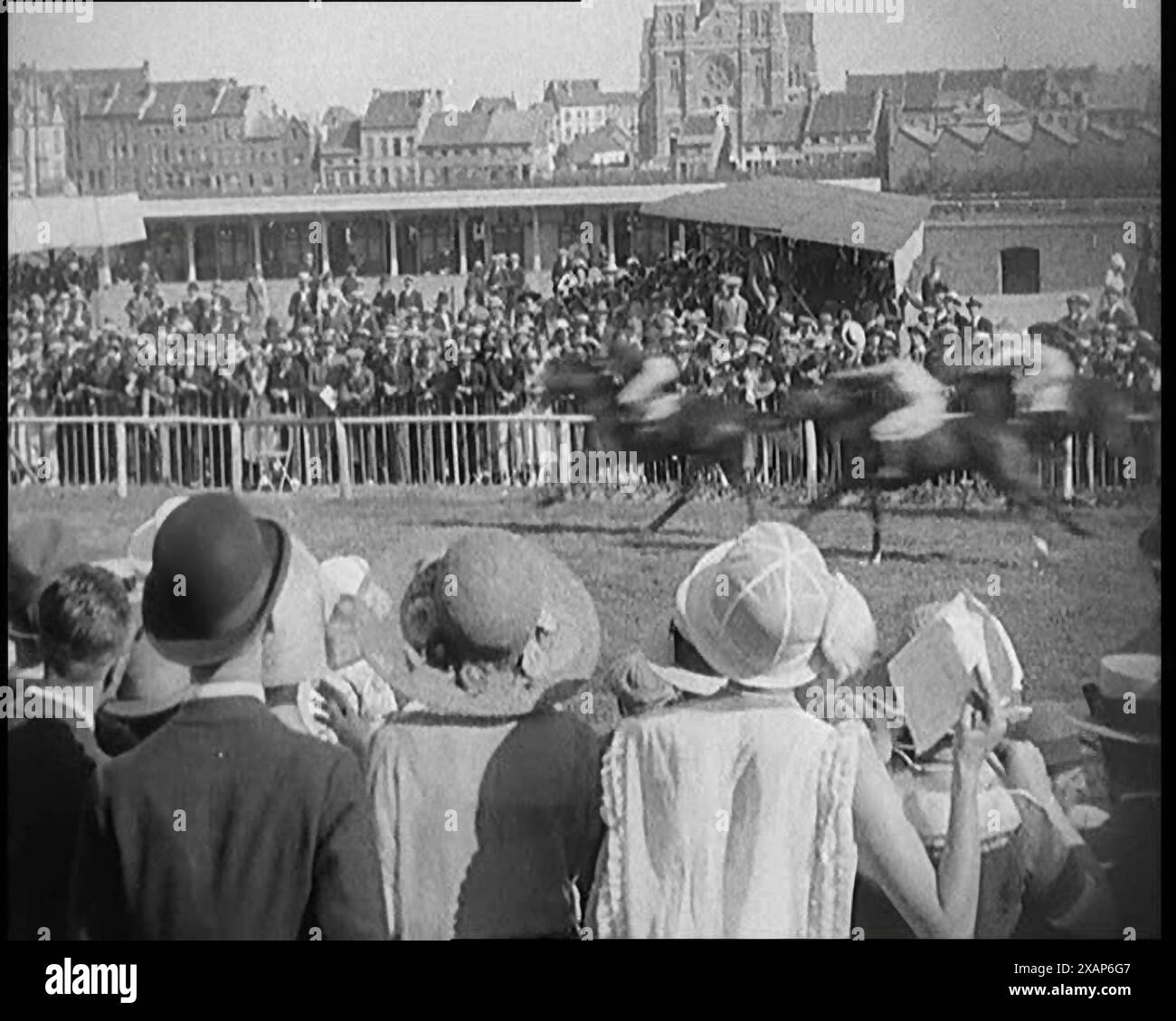 A Large Crowd of Civilians Wearing Smart Outfits and Hats Watching a ...
