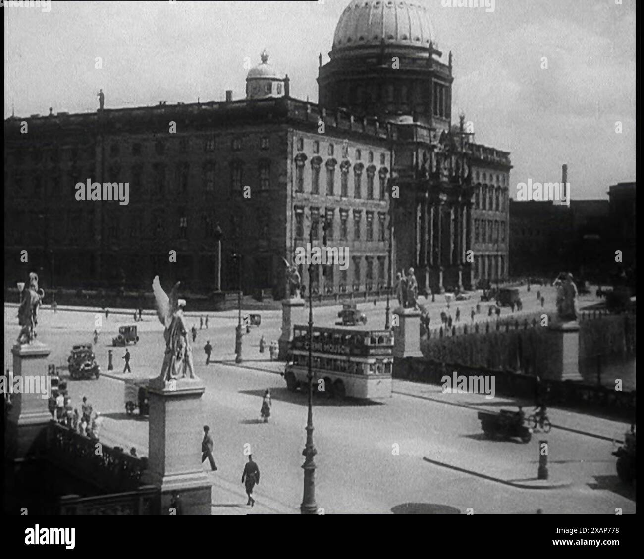 Bus Driving Down a Wide Road with a Large Building in the Background ...