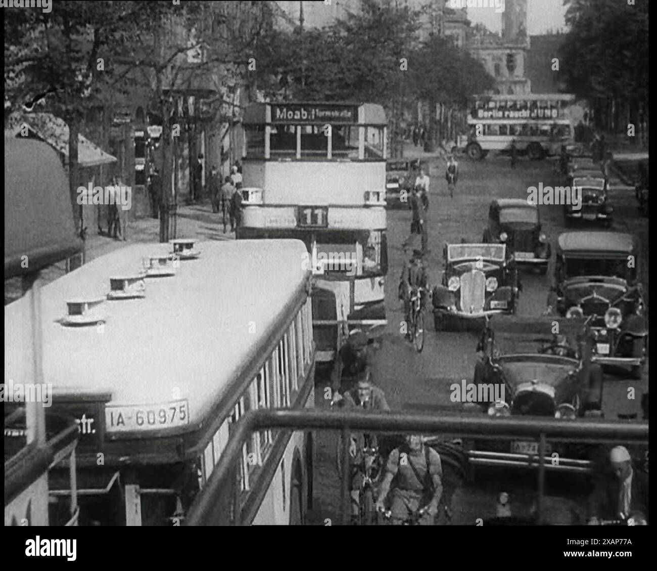 Buses, Cars and People on Bikes Driving Down the Road, 1933. From "Time ...