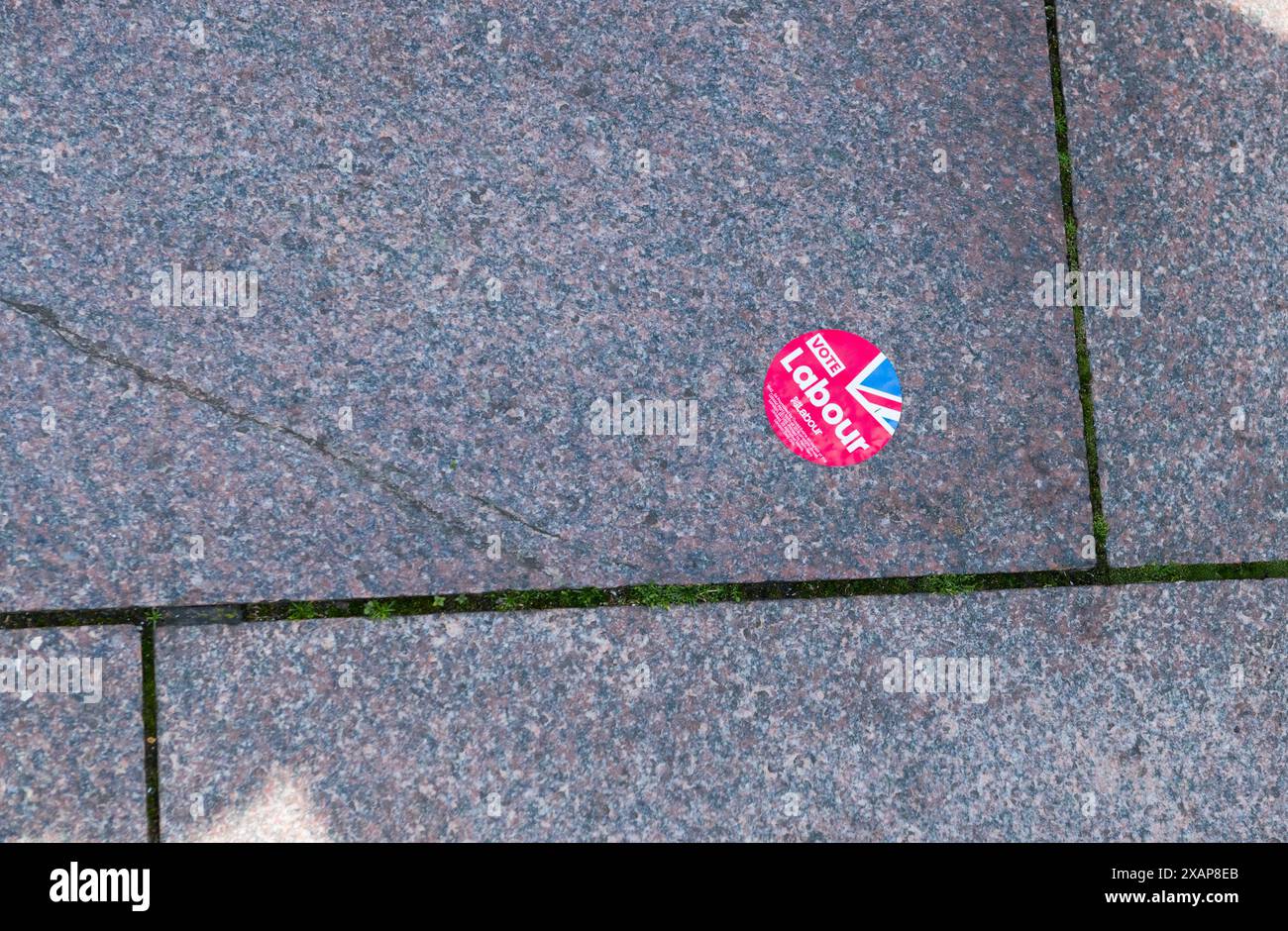Round vote labour sticker stuck to a pavement slab Stock Photo - Alamy