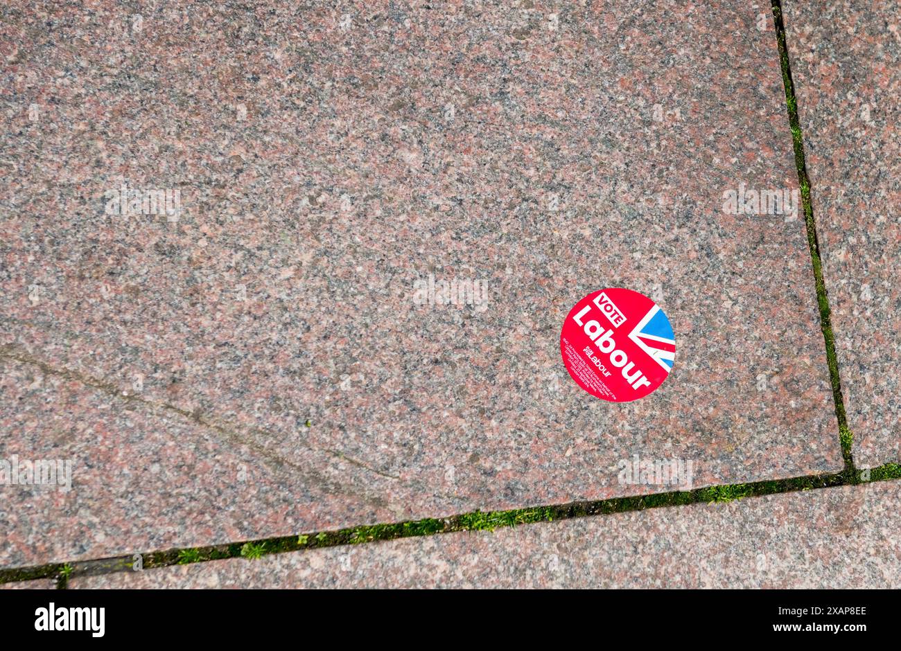 Round vote labour sticker stuck to a pavement slab Stock Photo - Alamy