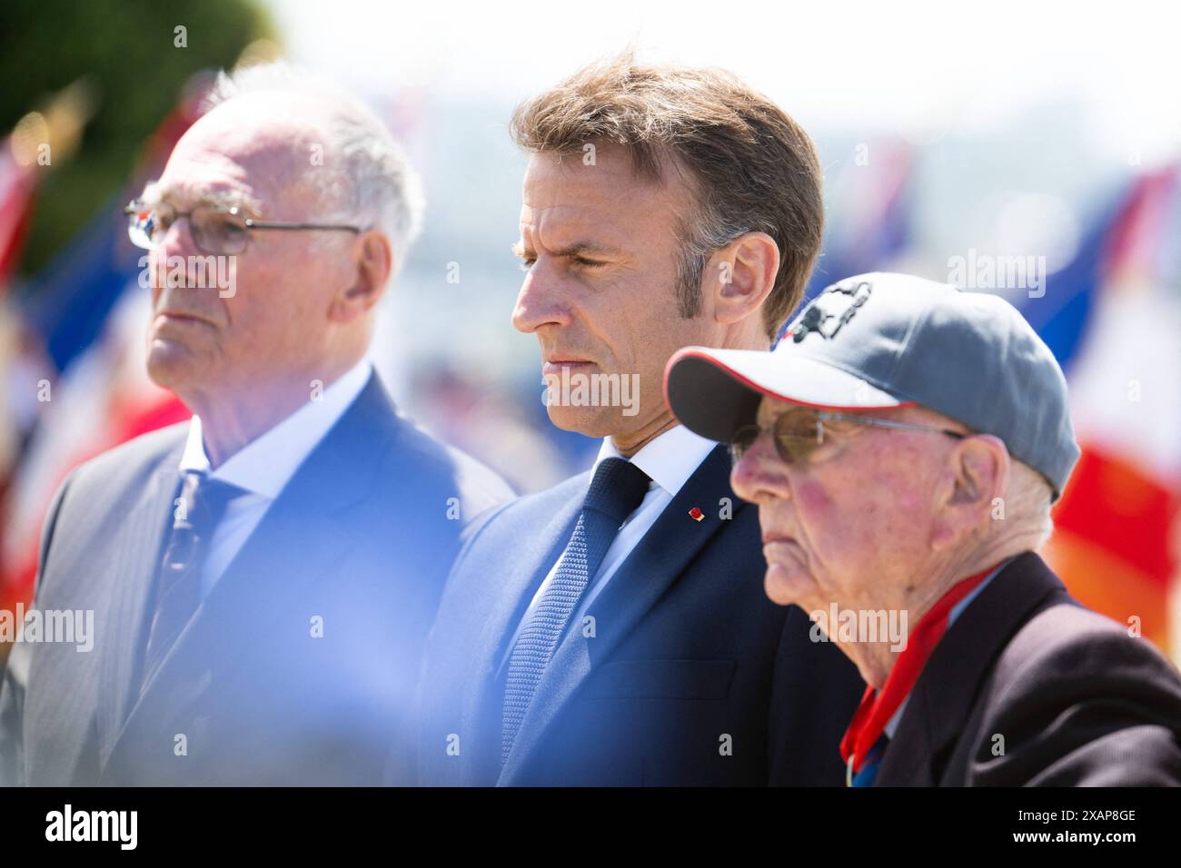 Emmanuel Macron and a veteran lay a wreath of flowers in tribute ...