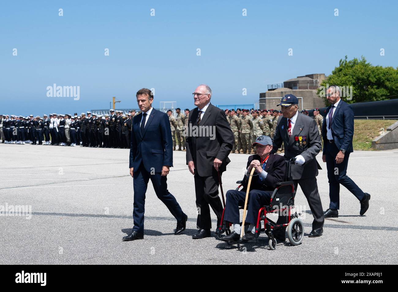 Emmanuel Macron and a veteran lay a wreath of flowers in tribute ...
