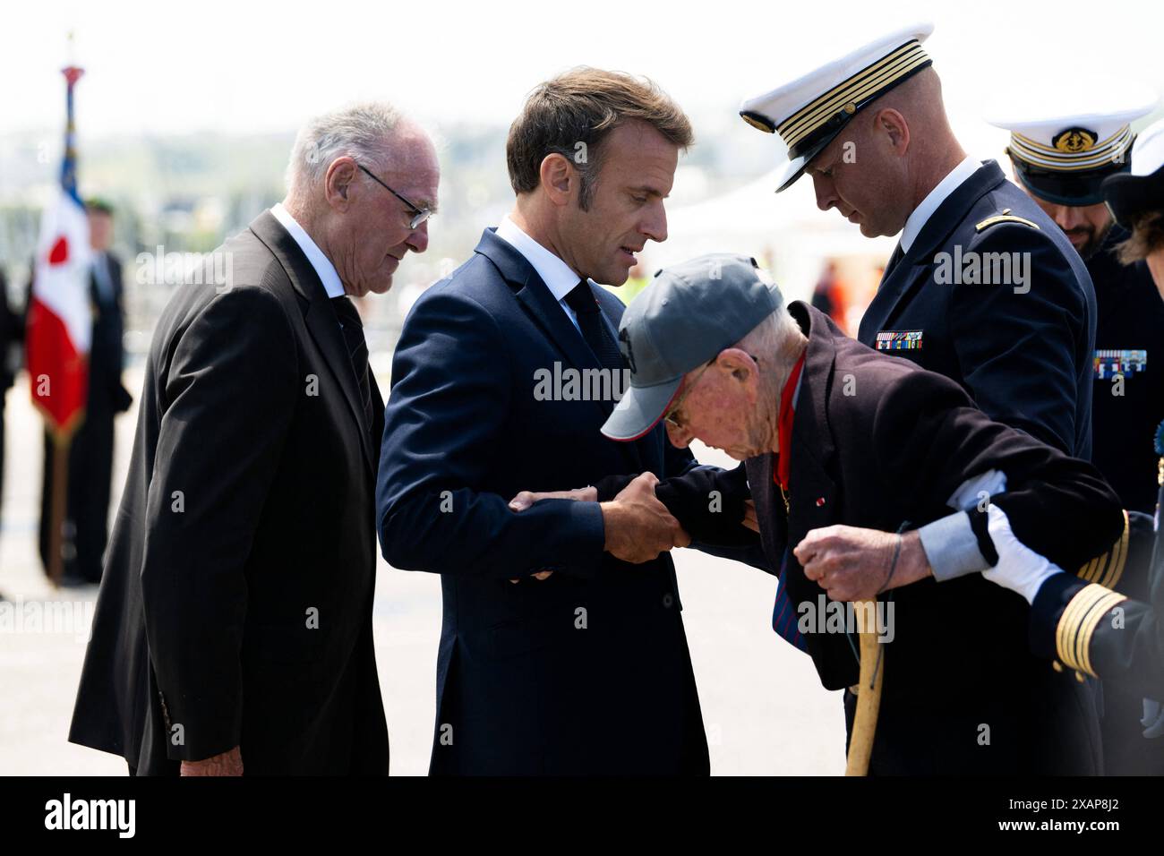 Emmanuel Macron and a veteran lay a wreath of flowers in tribute ...