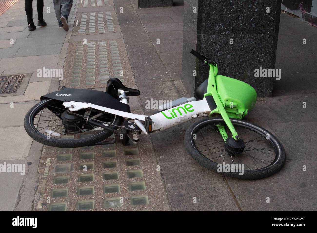 London, UK. 5th June, 2024. A discarded Lime e-bike left by a cyclist is a tripped hazard for ...