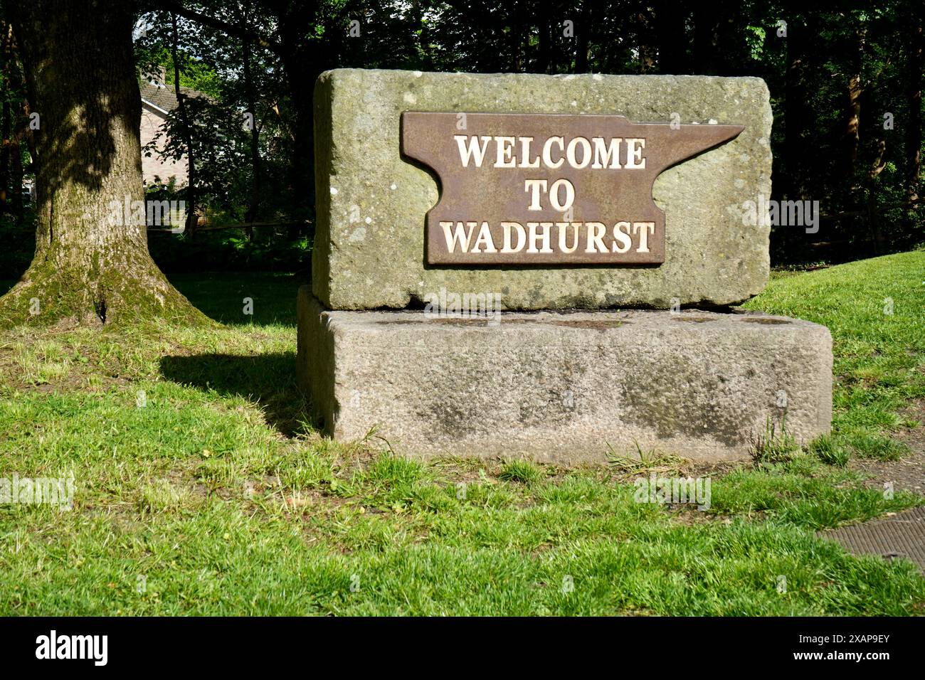 Anvil shaped metal and stone welcome to Wadhurst sign Stock Photo - Alamy