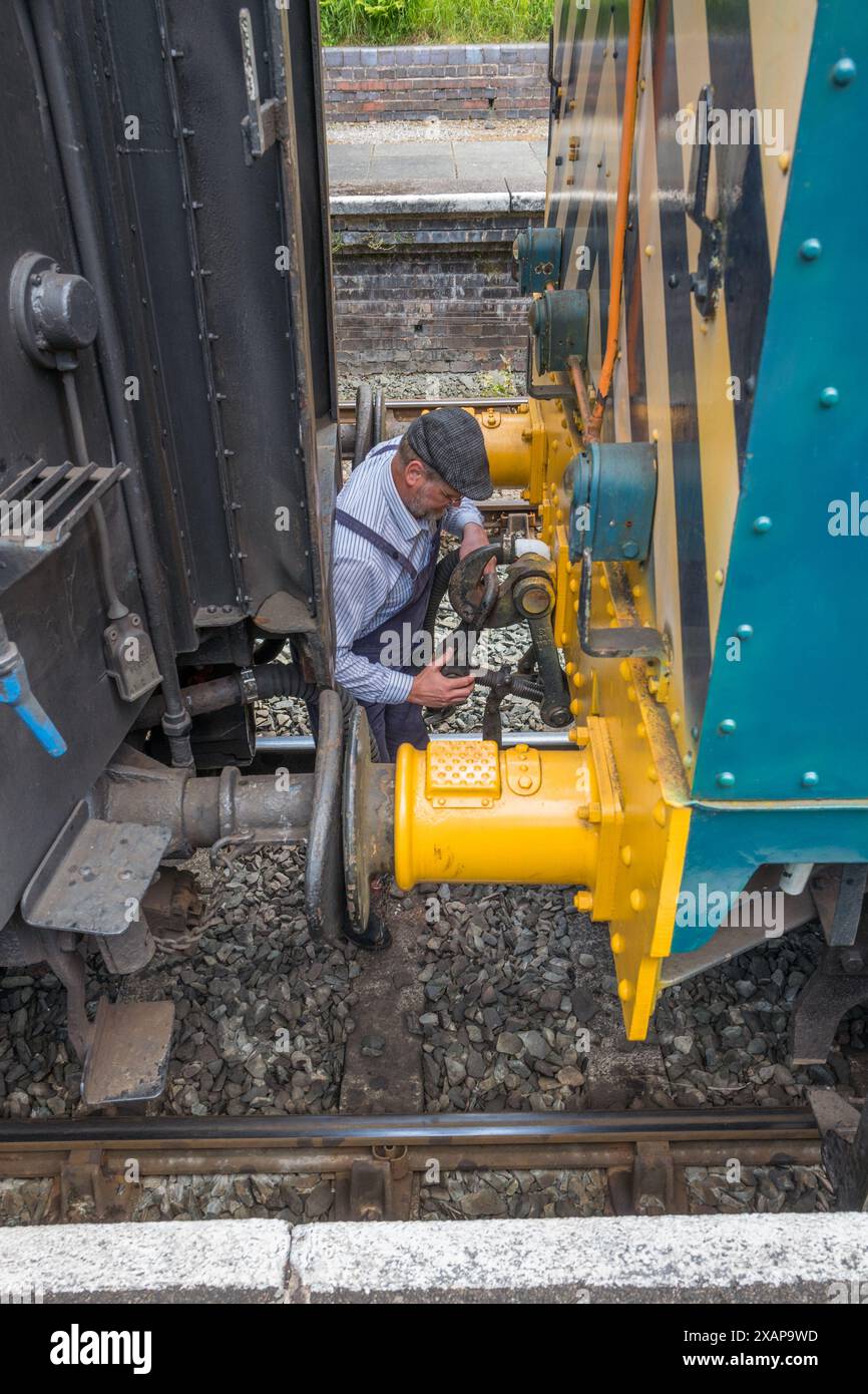 Train driver coupling up the passenger carrage to the restored Class 08 ...