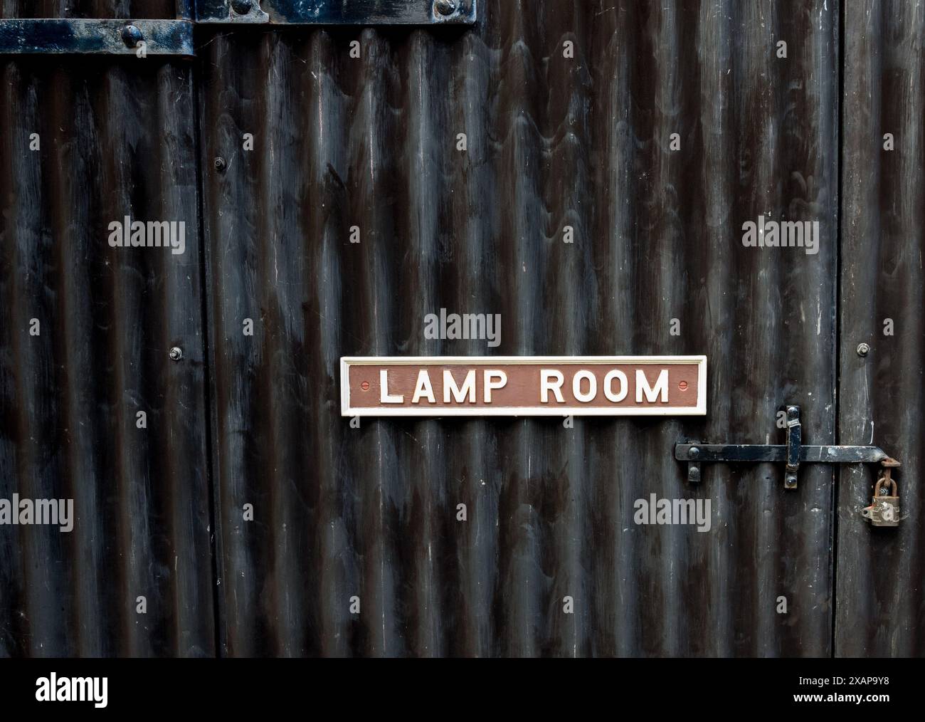 Metal Lamp Room sign attached to a corrigated metal shed with locks and ...