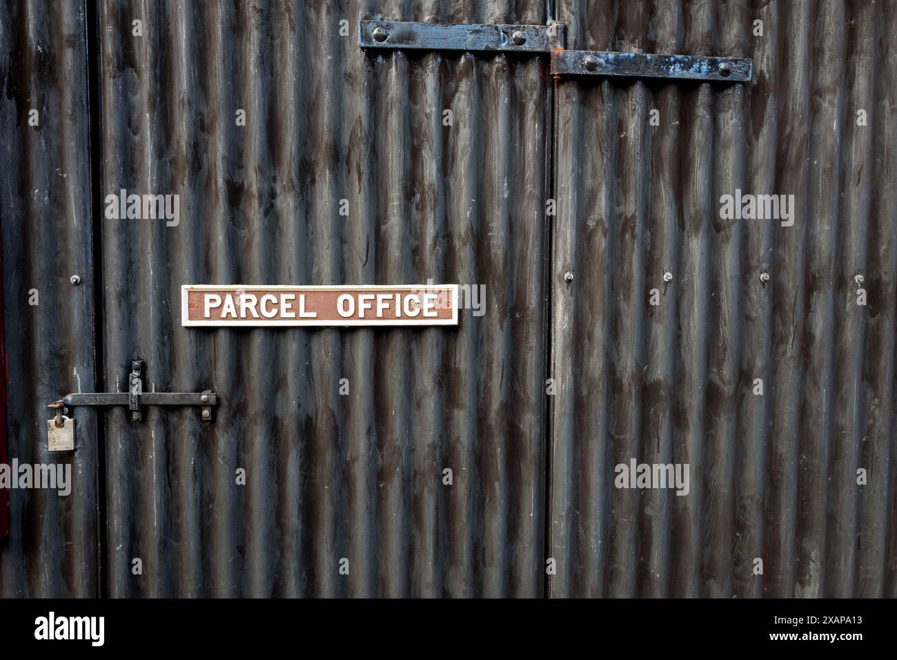 Metal Parcel Office sign attached to a corrigated metal shed with locks ...