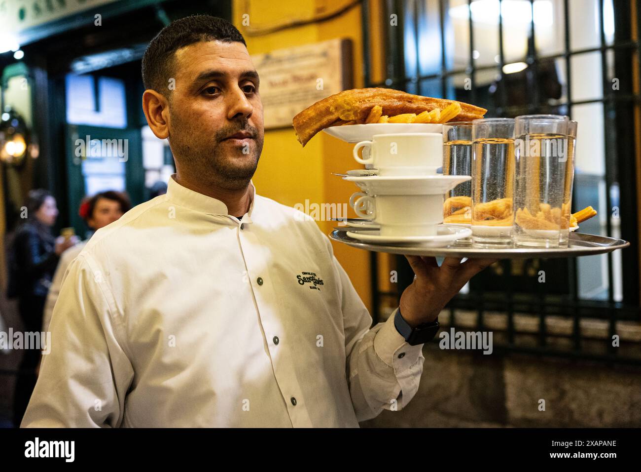 Madrid, Spain - 14 May 2023 : Waiter carrying a plate of churros and ...