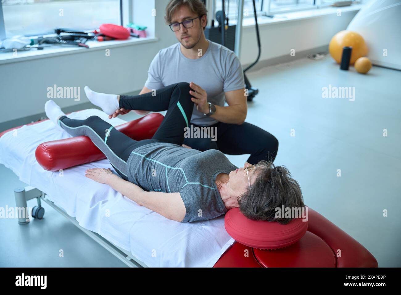 Rehabilitation therapist works with the hip joint of elderly lady Stock ...