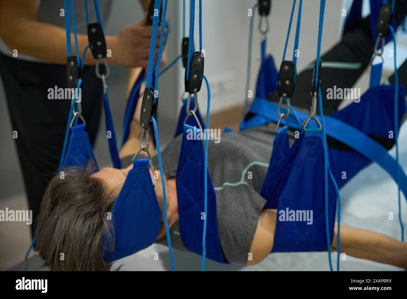 Fitness clinic specialist placed the patient on a suspension system ...