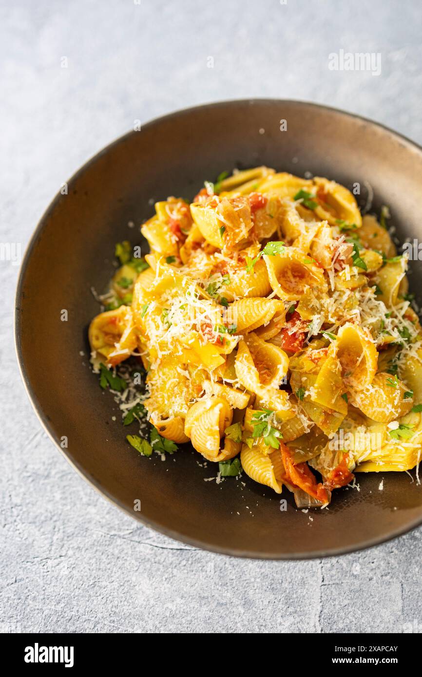 Shell pasta with artichoke, tomato and onion Stock Photo - Alamy