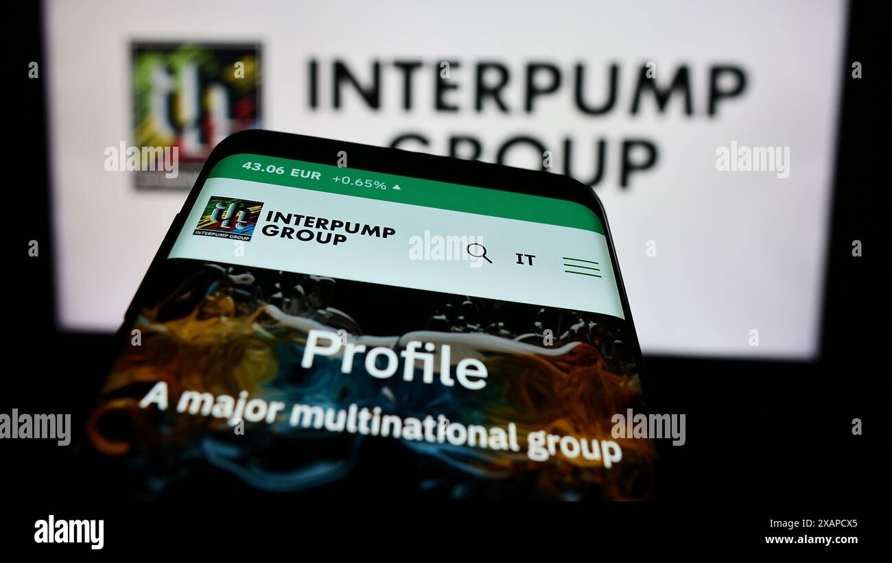 Mobile phone with webpage of Italian water pump company Interpump Group S.p.A. in front of ...