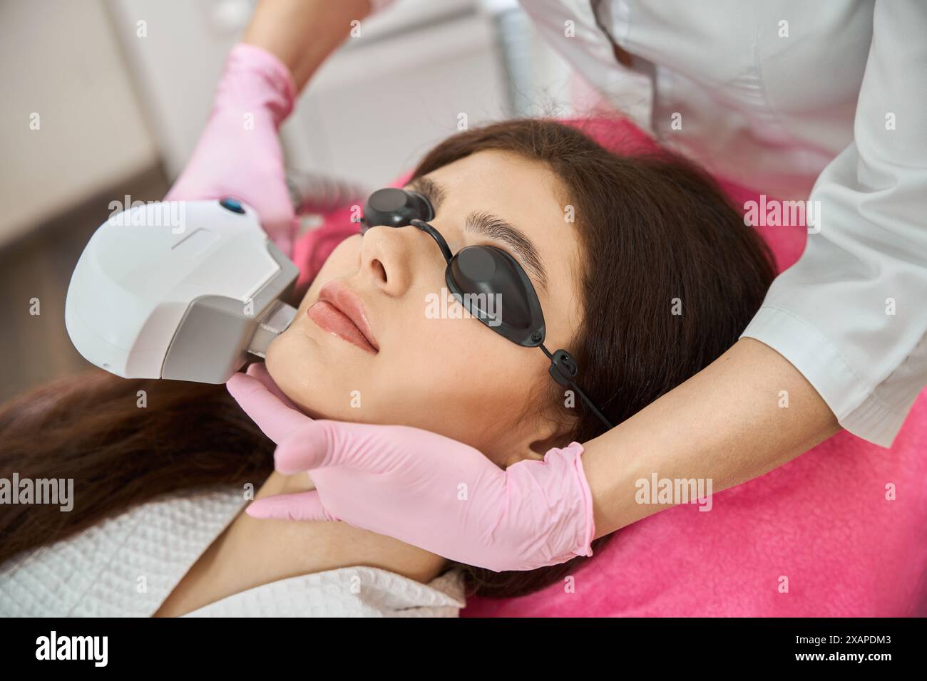 Woman undergoing intense pulsed light therapy performed by beauty ...