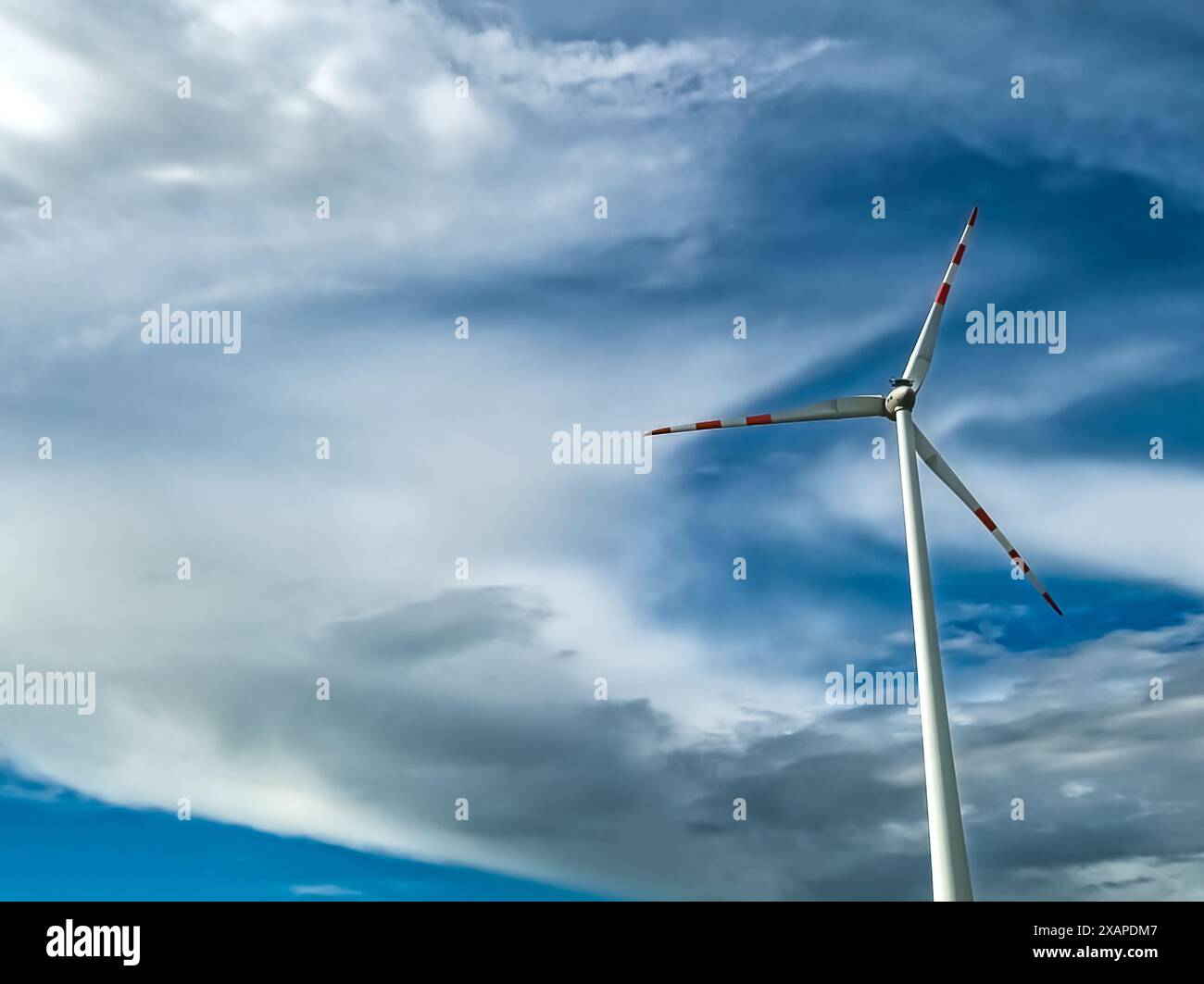 Wind Turbine In Front Of Blue Sky With Heavy Clouds Stock Photo - Alamy