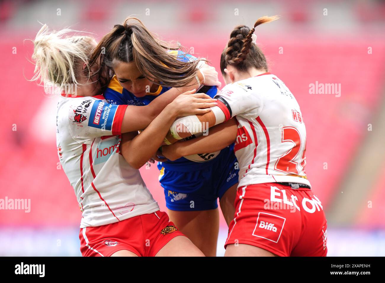 Leeds Rhinos' Ruby Enright (centre) is tackled by St Helens' Erin Stott ...
