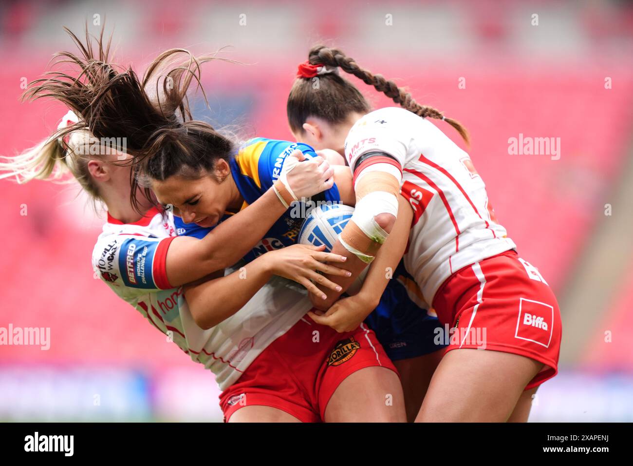 Leeds Rhinos' Ruby Enright (centre) is tackled by St Helens' Erin Stott ...