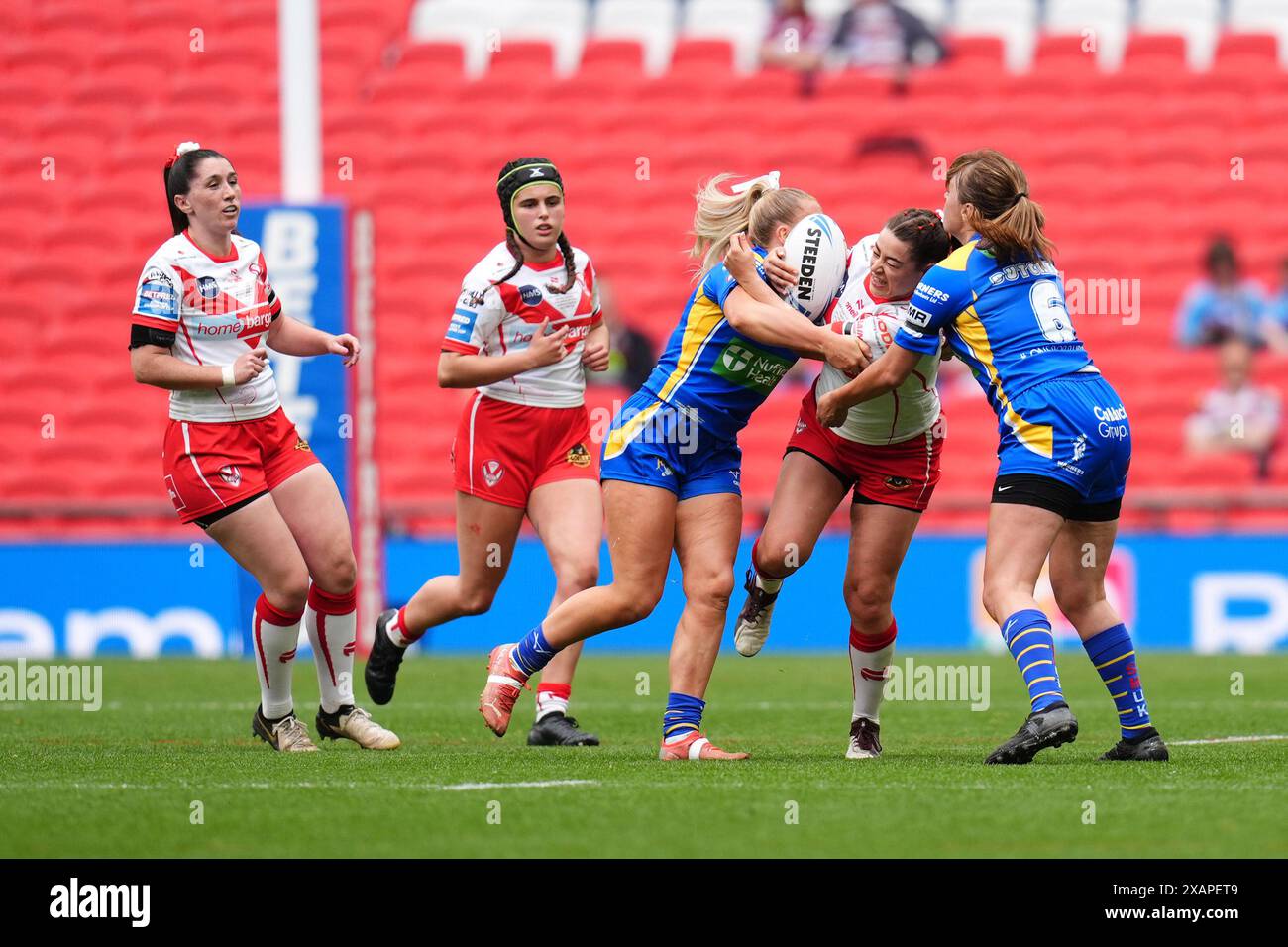 St Helens' Emily Rudge is tackled by Leeds Rhinos' Lucy Murray and ...