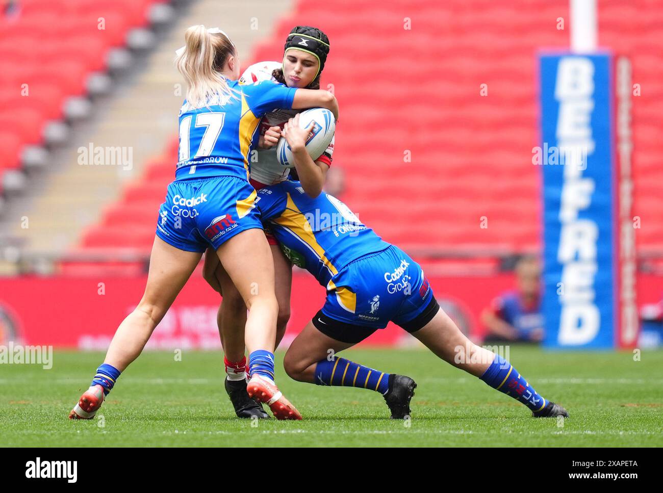 St Helens' Beri Salihi is tackled by Leeds Rhinos' Lucy Murray and ...