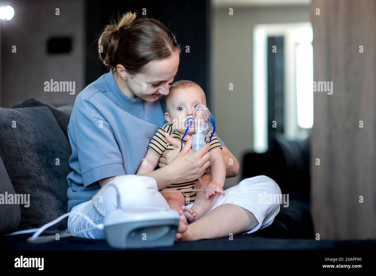 Mom giving nebulizer breathing treatment to sick infant baby at home ...