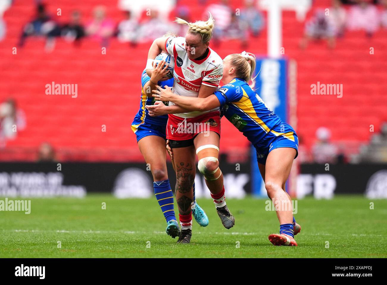 St Helens' Naomi Williams (centre) is tackled by Leeds Rhinos' Keara ...