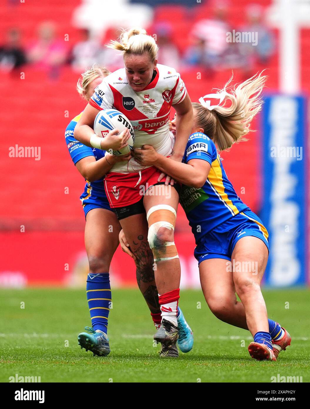 St Helens' Naomi Williams (centre) is tackled by Leeds Rhinos' Keara ...