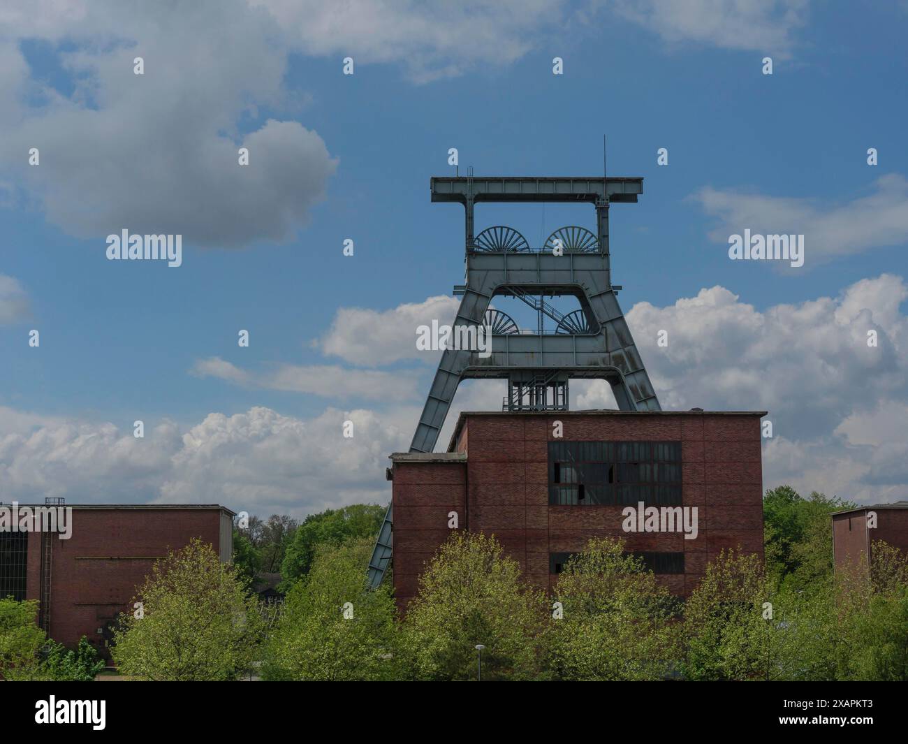 Historic industrial plant with shaft frame and brick buildings under a ...