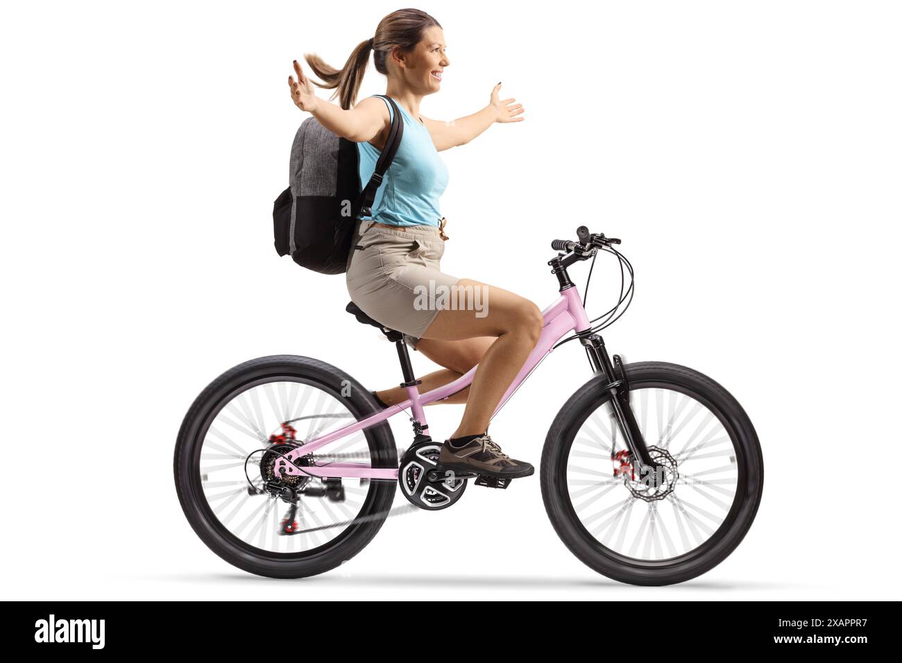 Full length profile shot of a woman with a backpack riding a bicycle ...