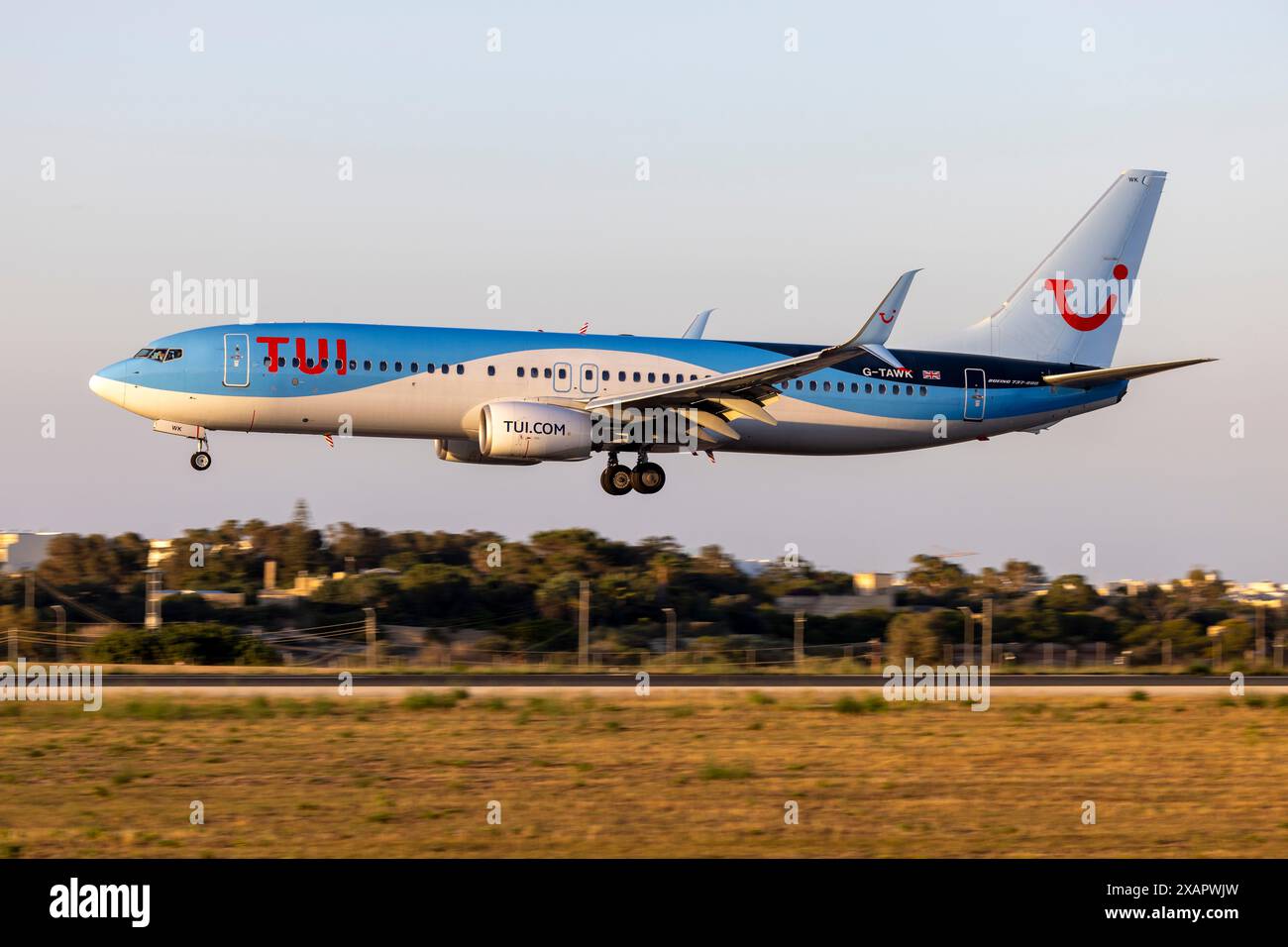 TUI Boeing 737-8K5 (REG: G-TAWK) landing as the sun is setting Stock ...