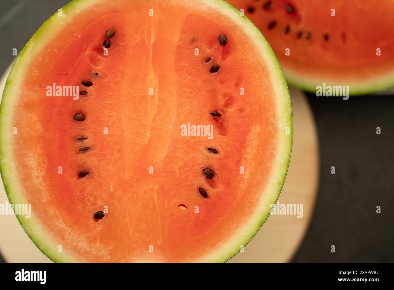 Top view and close up on water melon cut in half on bright wooden board ...
