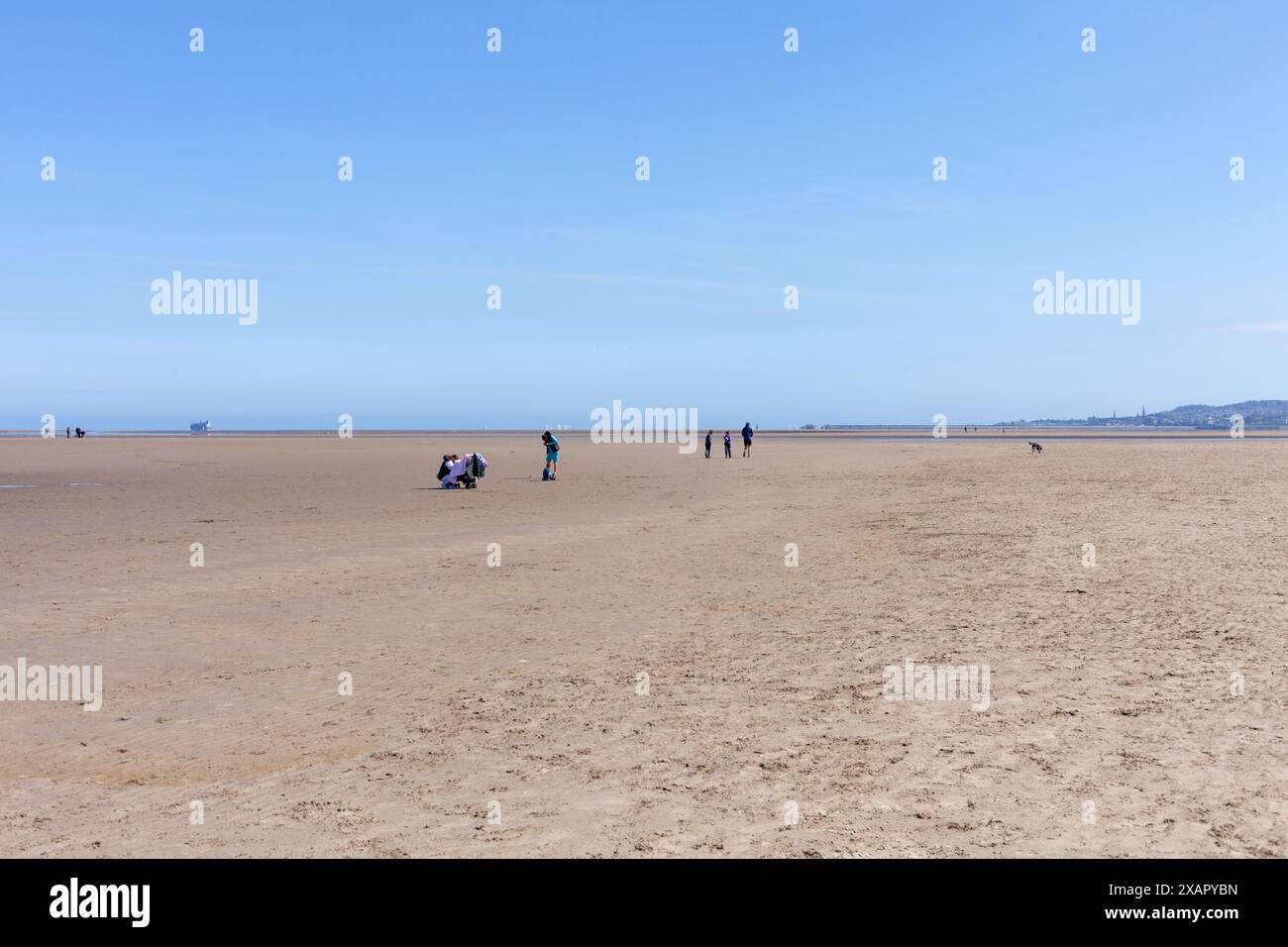 Sandymount beach during low tide. There are people on the sand enjoying ...