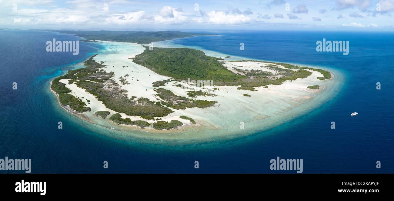 A diverse coral reef fringes a scenic and remote island, Pulau Selu, in ...