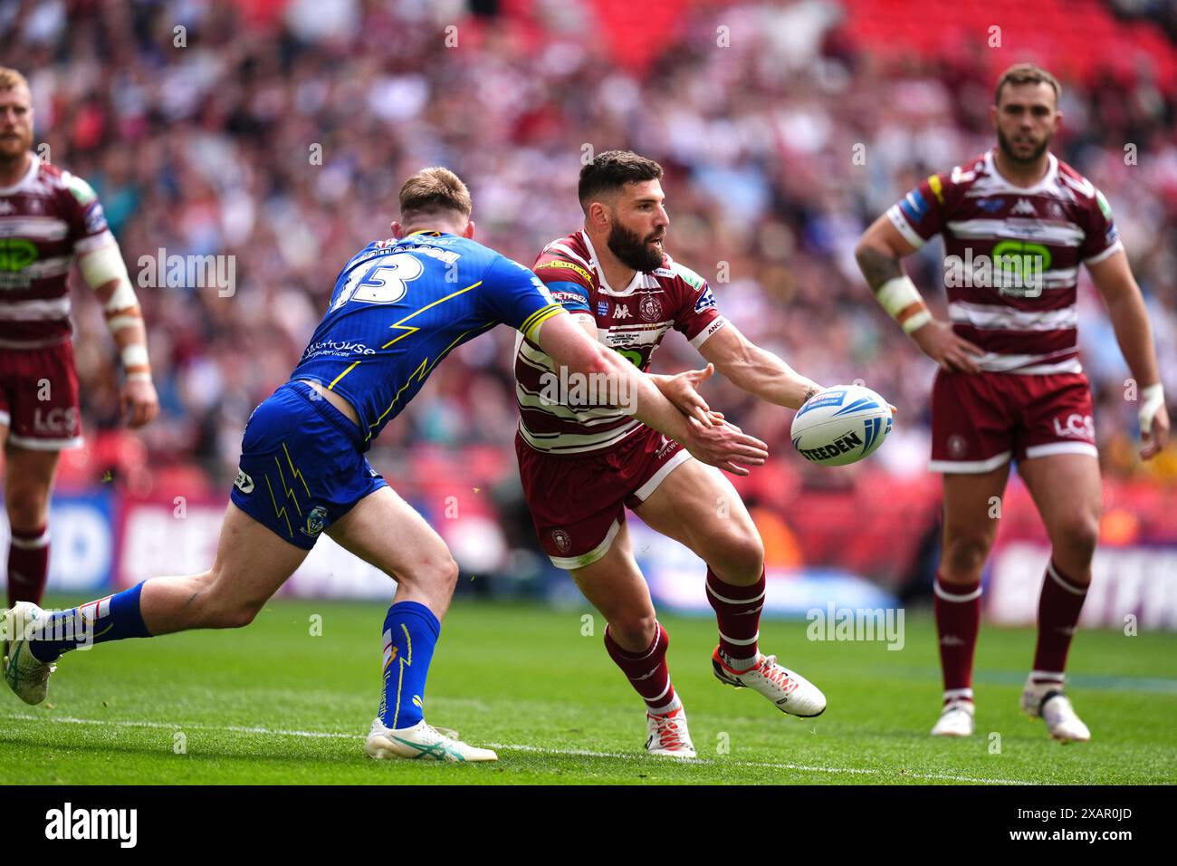 Wigan Warriors' Abbas Miski releases the ball before being tackled by ...