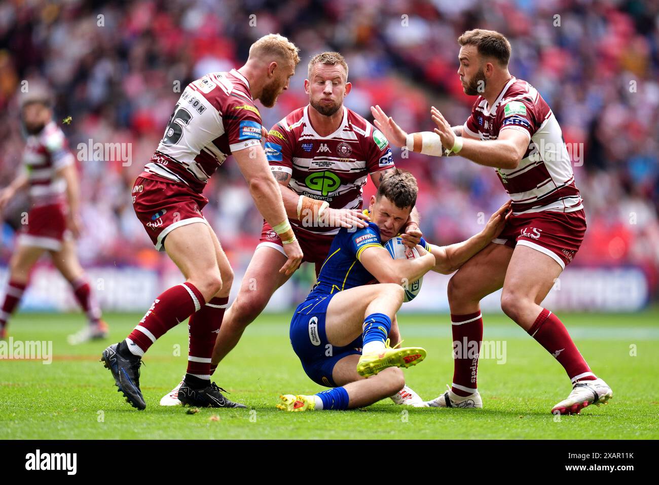 Warrington Wolves' Josh Thewlis (centre) is tackled by Wigan Warriors ...