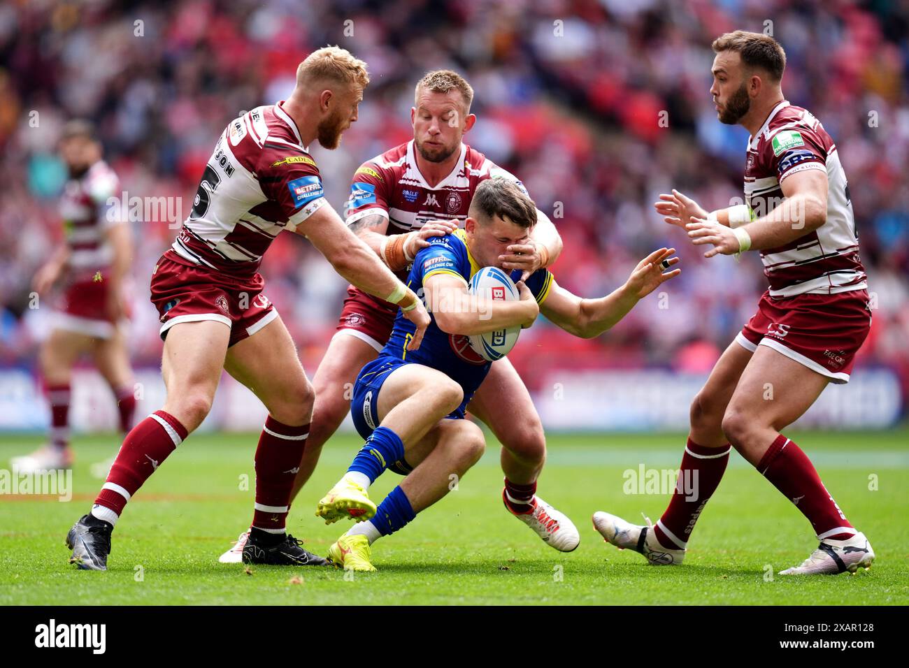 Warrington Wolves' Josh Thewlis (centre) is tackled by Wigan Warriors ...