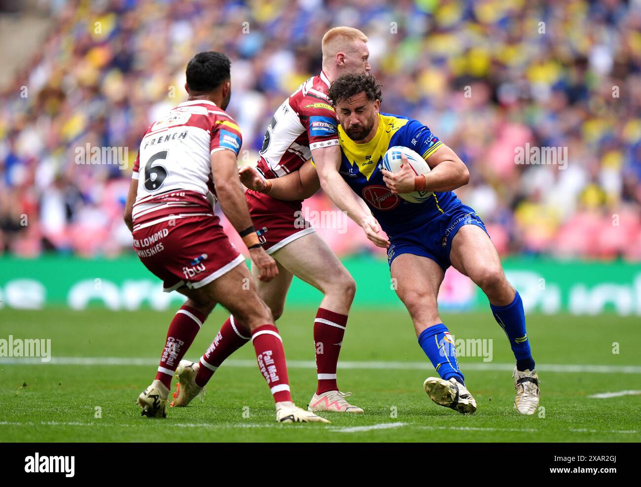 Warrington Wolves' Toby King (right) is tackled by Wigan Warriors ...