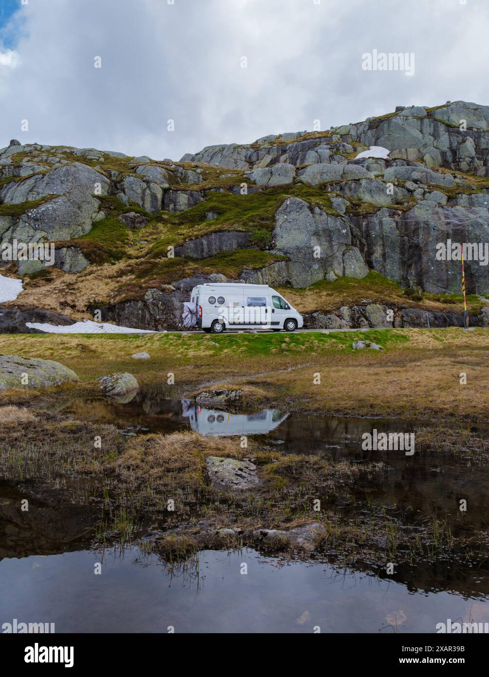 A white camper van is parked on a winding road through the rugged ...