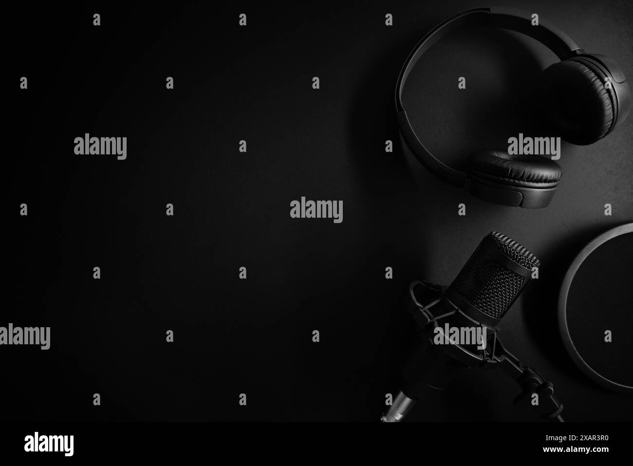 studio microphone and headphones on black background with copy space ...