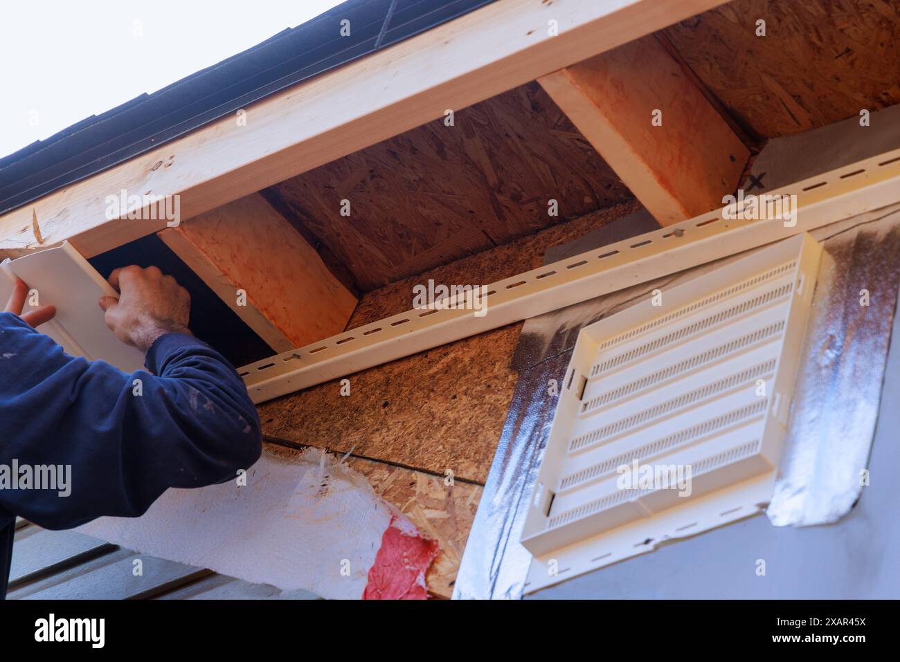 An installation vinyl white uPVC soffit boards below facia roof along ...