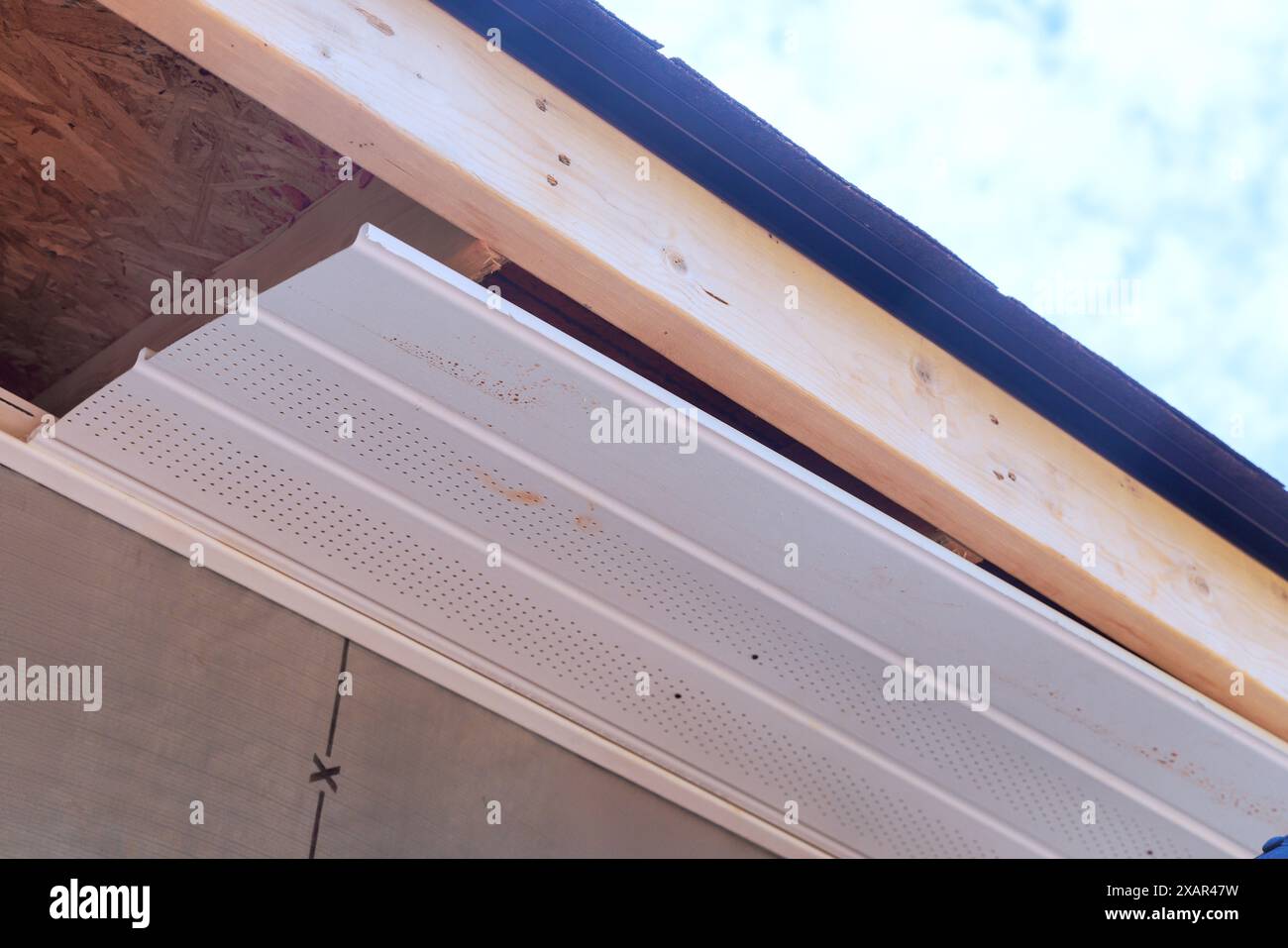 Worker installation of upvc soffit boards on roof corners ceiling ...