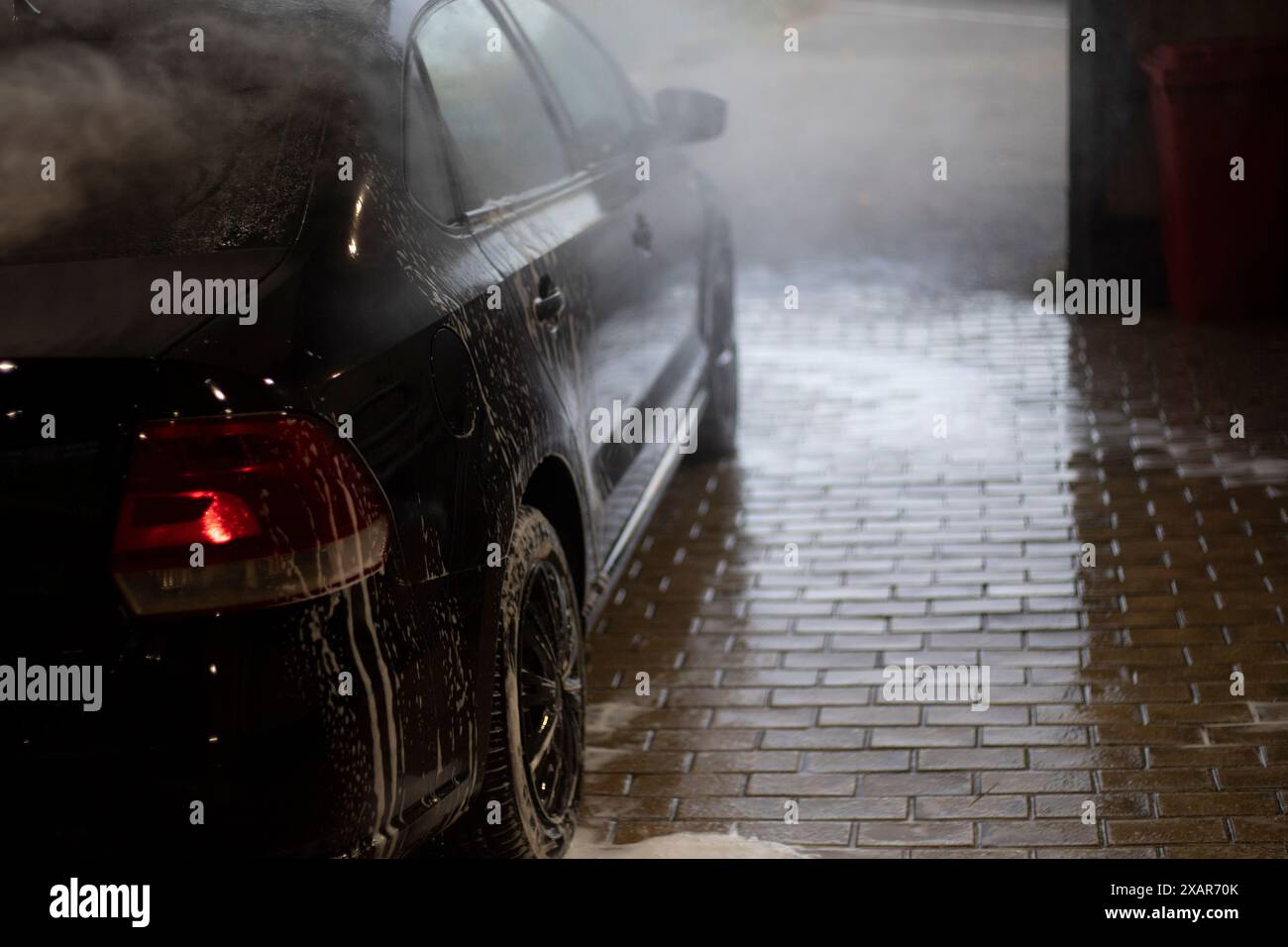 Car at the car wash. Black car in the garage. Washing dirt from the ...