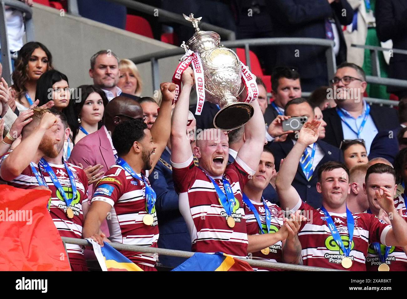 Wigan Warriors' Liam Farrell (centre) lifts the trophy with team-mates ...