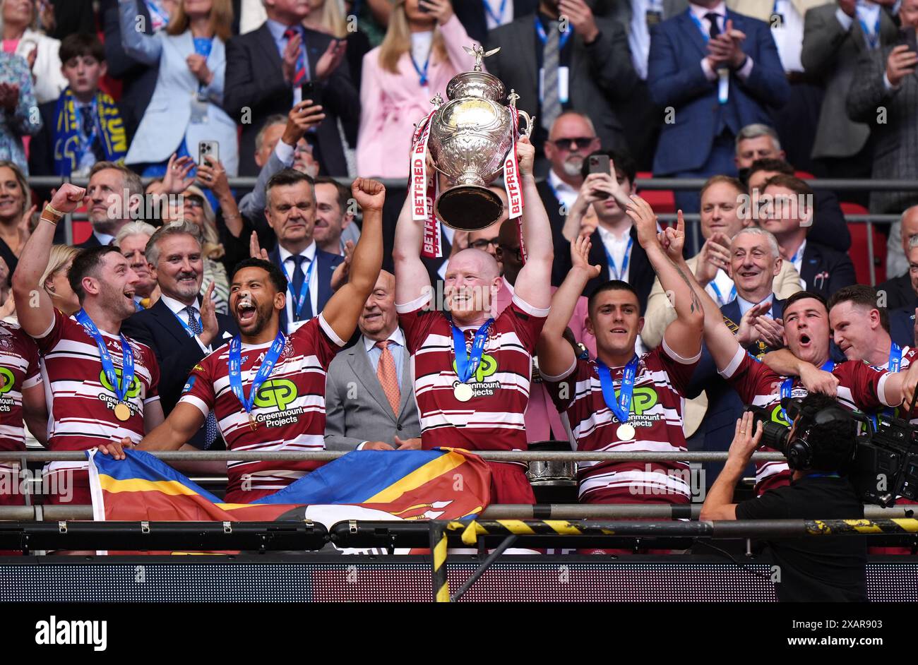 Wigan Warriors' Liam Farrell (centre) lifts the trophy with team-mates ...