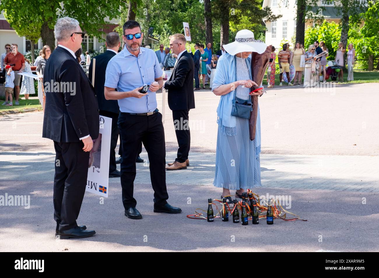 A grandmother waits with mini-bottles of champagne as families and ...