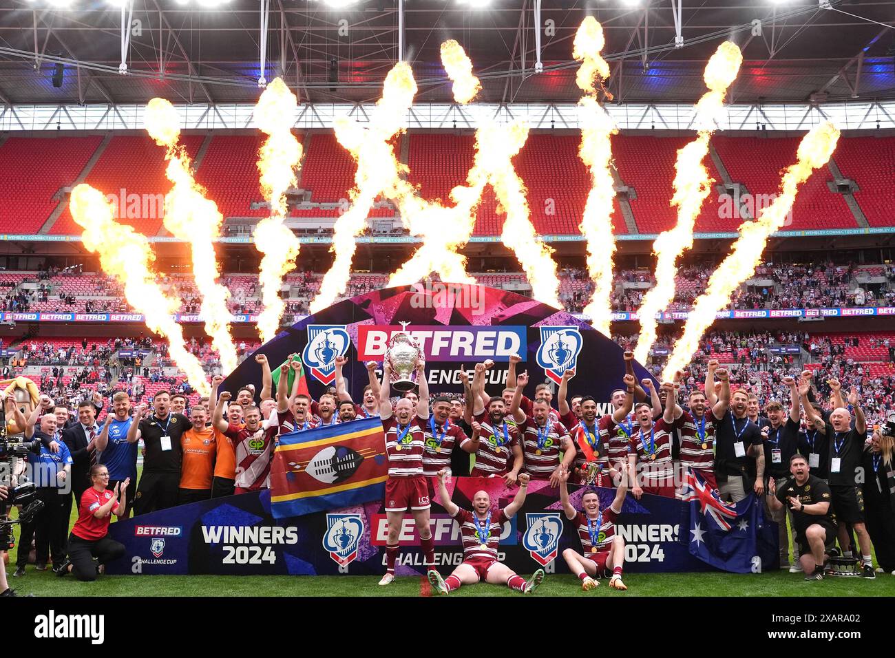 Wigan Warriors' Liam Farrell (centre) lifts the trophy with team-mates ...