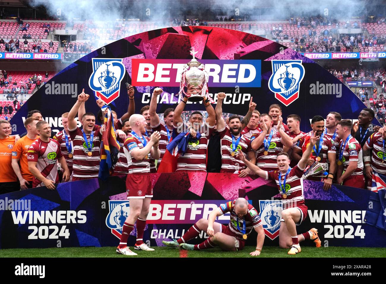 Wigan Warriors' Patrick Mago (centre) lifts the trophy with team-mates ...