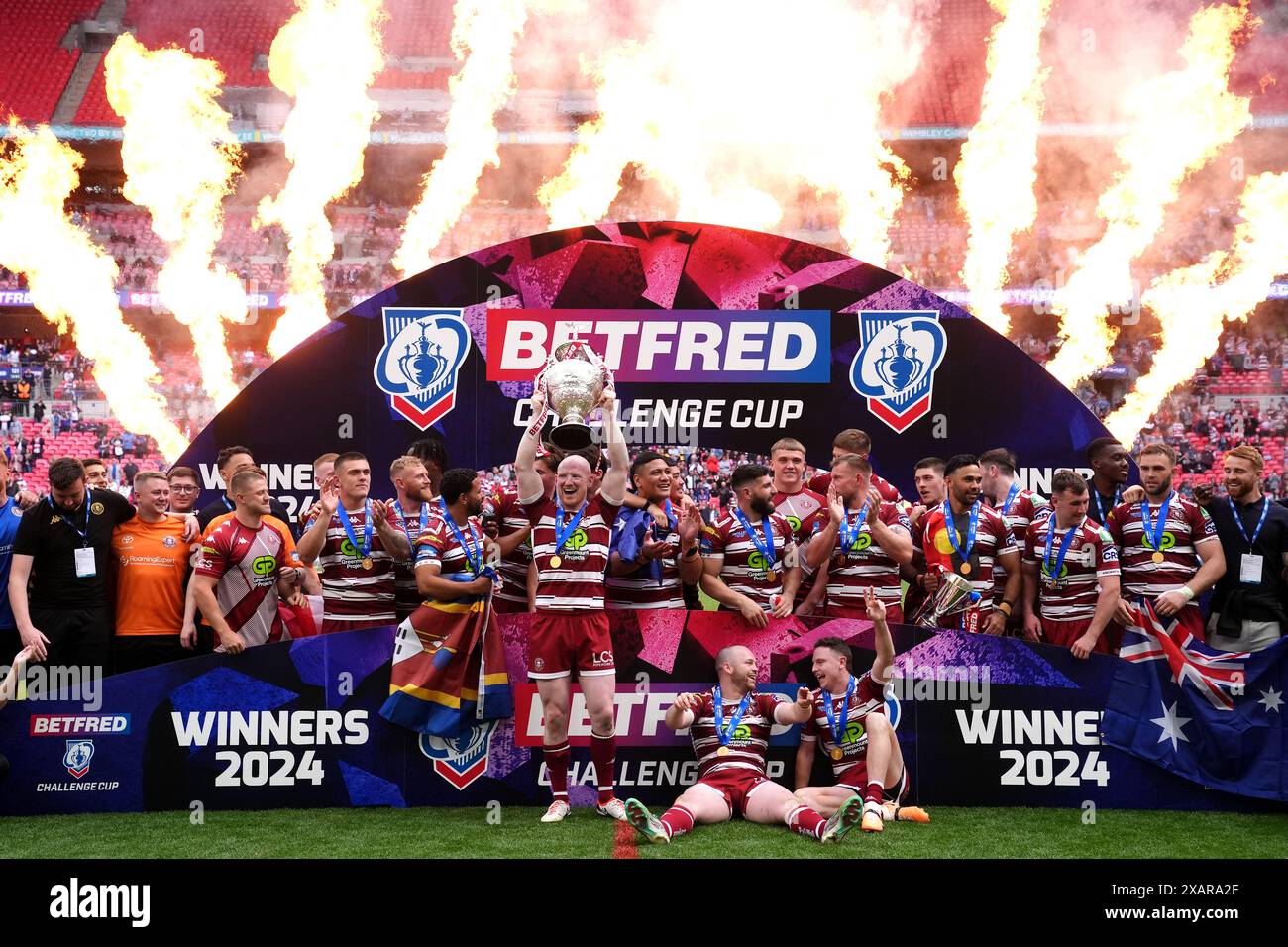 Wigan Warriors' Liam Farrell (centre) lifts the trophy with team-mates ...