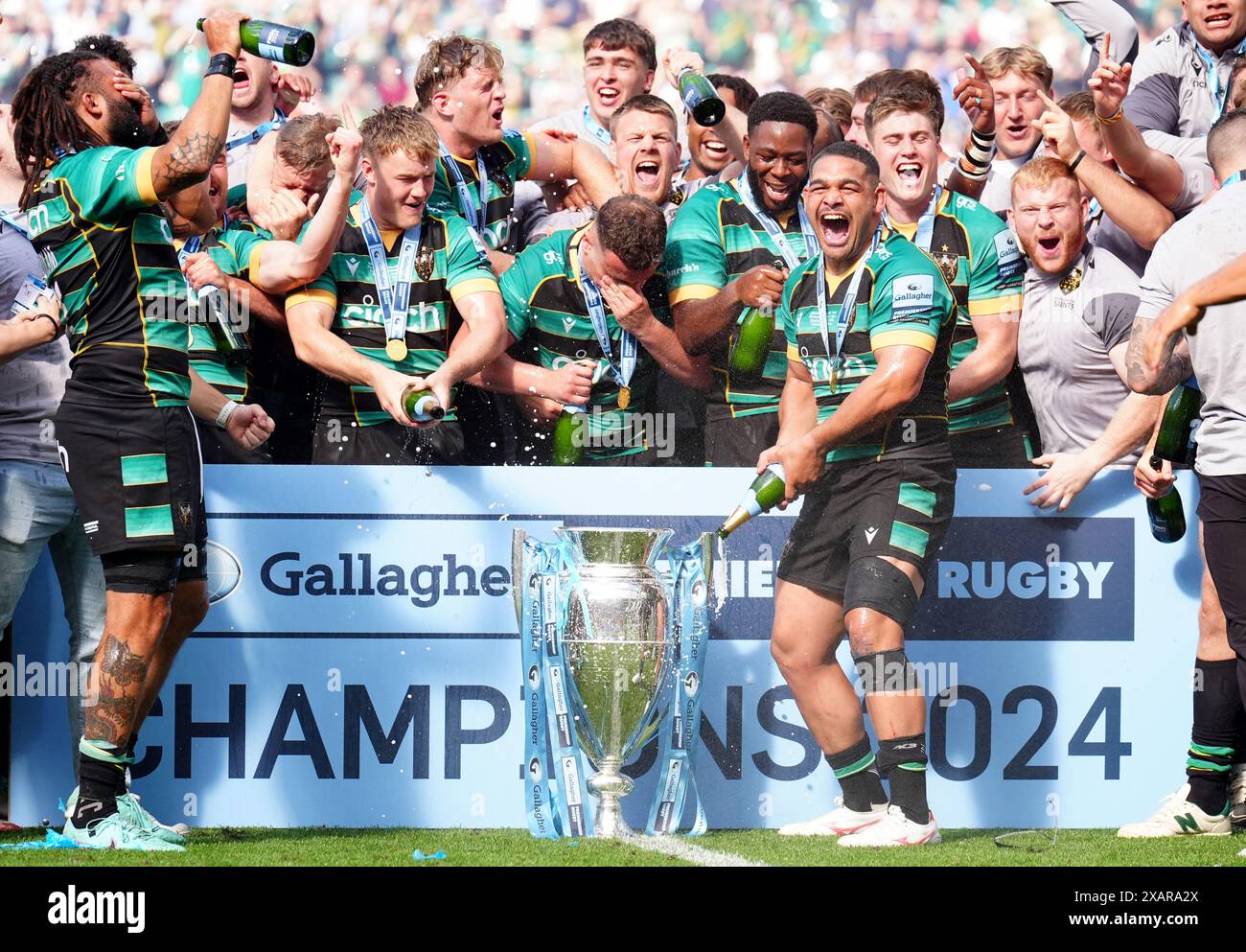 Northampton Saints players celebrate on the pitch with the trophy after ...